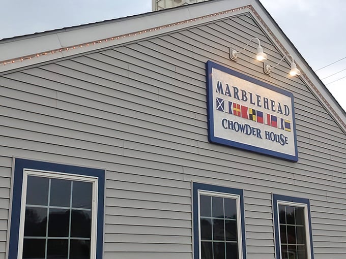 Colorful nautical flags adorn the Marblehead sign, a silent promise of maritime delights within. Those little lights aren't just for show—they're guiding you to chowder nirvana.