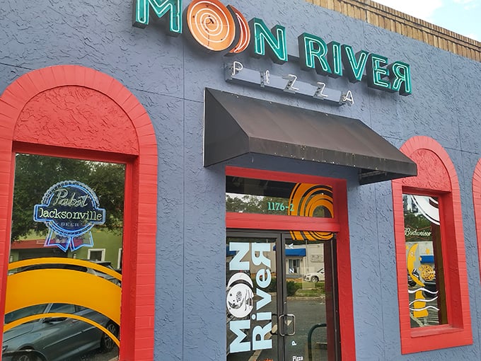 The blue exterior with vibrant neon signage announces you've arrived somewhere special. Moon River's façade promises a colorful pizza adventure inside.