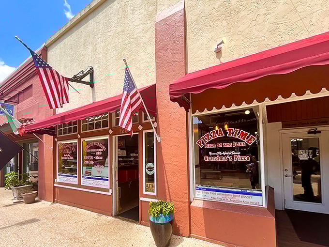 Pizza Time's charming storefront stands as a beacon for pizza lovers. The Italian and American flags hint at the authentic flavors within.