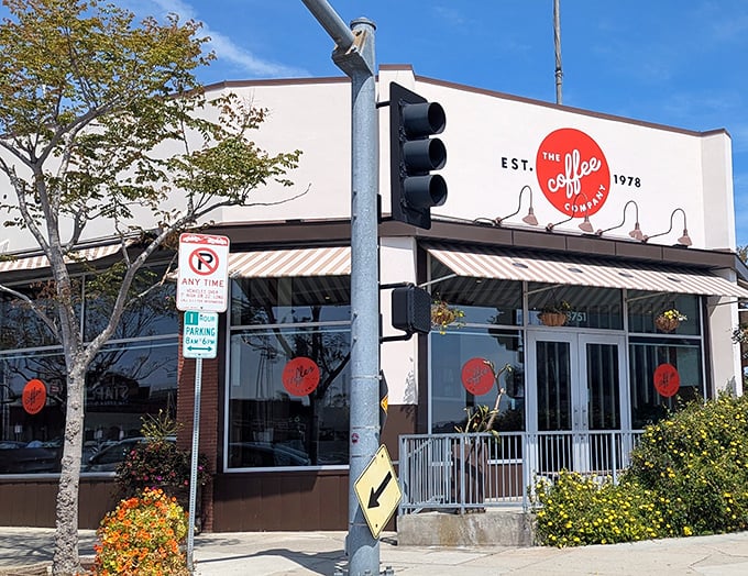 The Coffee Company's corner location basks in California sunshine, its iconic red logo promising morning salvation to caffeine-seekers and breakfast enthusiasts alike.