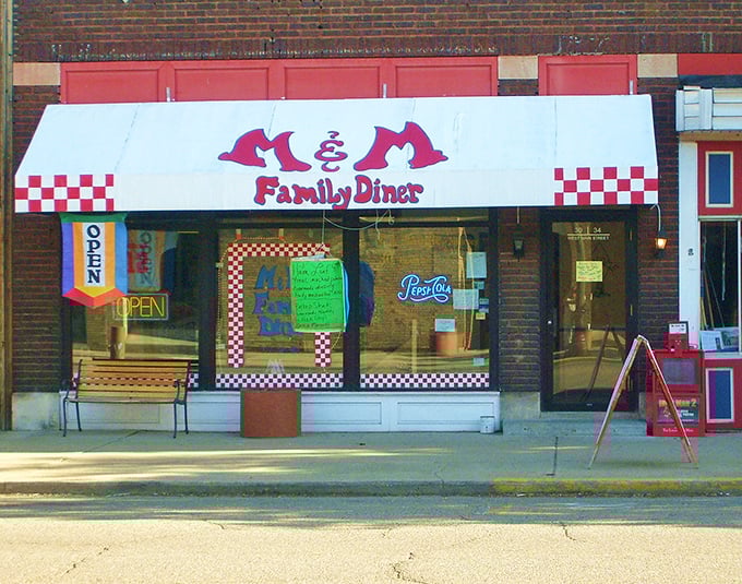 The classic red and white awning of M & M Family Diner beckons like a beacon to hungry travelers, promising comfort food salvation in downtown Logan.