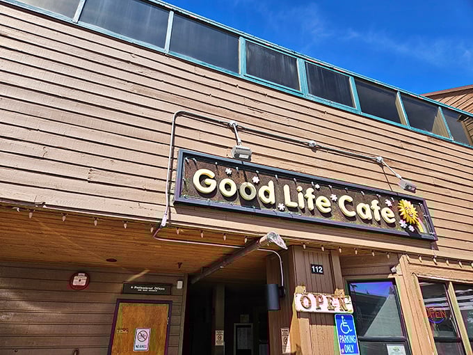 The unassuming wooden exterior of Good Life Cafe proves once again that culinary treasures often hide in plain sight. That sunflower sign promises warmth inside!
