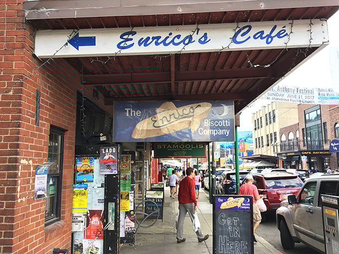 Welcome to flavor town! Enrico's Café beckons hungry visitors with its unassuming brick storefront and blue sign—Pittsburgh's worst-kept culinary secret hiding in plain sight.