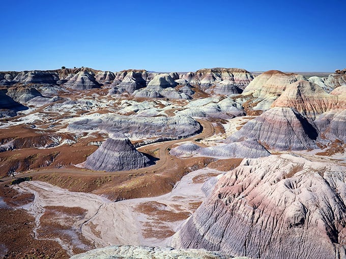Nature's own color palette on full display. The Painted Desert stretches toward the horizon like a watercolor masterpiece that forgot to stop at the canvas edge.