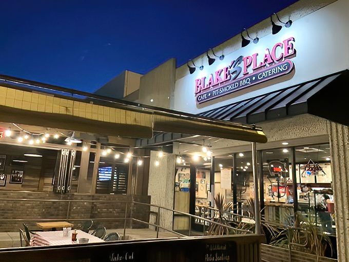The neon sign glows like a barbecue beacon in the night, promising smoky salvation to weary travelers. No fancy frills, just the promise of meat done right.
