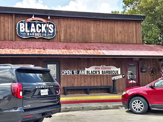 The barbecue beacon of Lockhart stands proud with its weathered wood exterior and iconic red tin roof—Texas authenticity you can spot from a mile away.