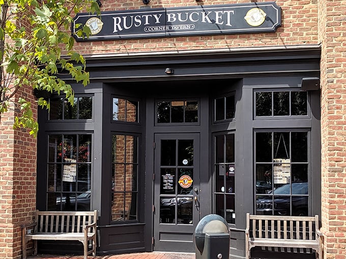 The brick façade and wooden benches at Rusty Bucket's entrance aren't just charming—they're practically whispering "come in, stay awhile" to every passerby.