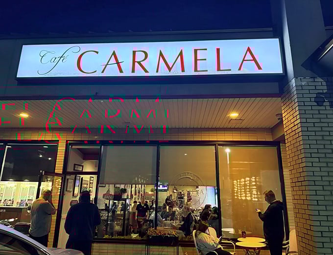 The glowing red letters of Cafe Carmela beckon like a lighthouse for the hungry. This unassuming storefront houses culinary treasures worth discovering.