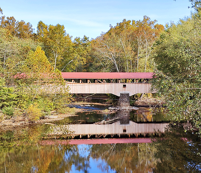 The iconic red roof of Pomeroy-Academia Covered Bridge stands out against Pennsylvania's blue sky like nature's perfect postcard.