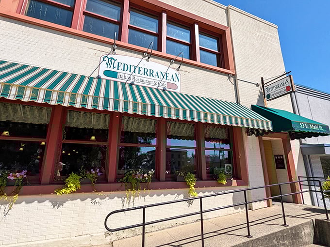 The iconic green and white striped awning of The Mediterranean is like a beacon for hungry travelers on Wilmington's Main Street, promising authentic flavors behind its modest façade.