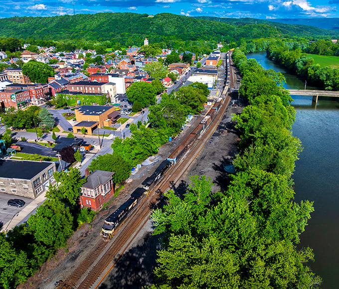 Huntingdon's aerial view reveals nature's perfect sandwich—town nestled between rolling mountains and the winding Juniata River. Small-town charm with big-time scenery.