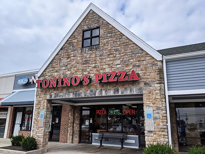Bathed in golden sunlight, Tonino's distinctive peaked roof and stone exterior create an inviting first impression that promises comfort food within.