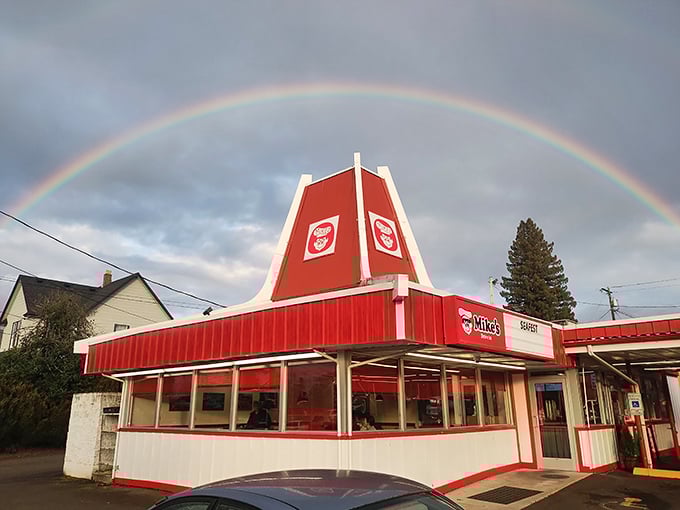 A rainbow arches perfectly over Mike's Drive-In, as if nature itself is pointing hungry travelers toward burger paradise.