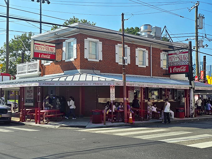 The iconic red and white brick corner of Pat's King of Steaks stands like a culinary lighthouse, guiding hungry pilgrims to cheesesteak nirvana.