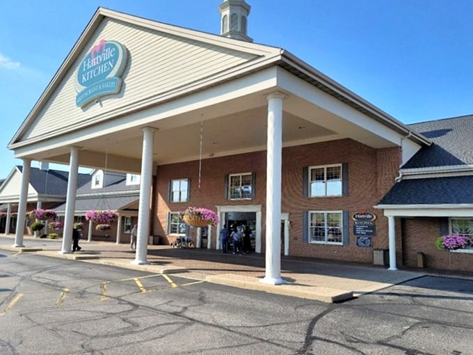 The welcoming facade of Hartville Kitchen stands proudly with its white columns and hanging flower baskets, like a culinary embassy of comfort food.