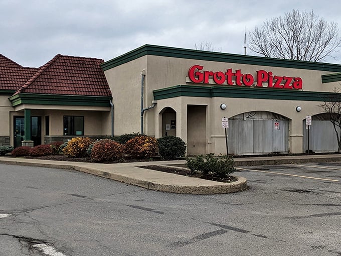 The iconic red Grotto Pizza sign beckons hungry travelers like a lighthouse guiding ships to delicious harbor.
