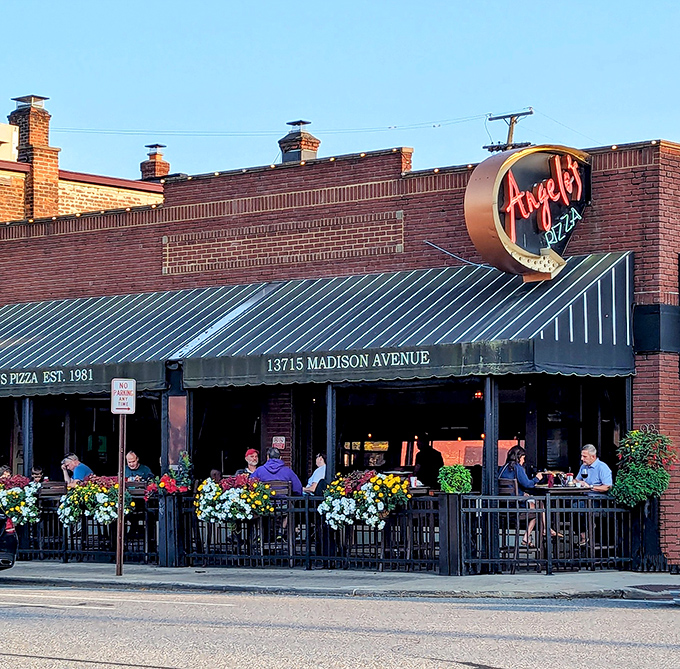 The iconic Angelo's Pizza storefront on Madison Avenue beckons with its vintage neon sign and flower-adorned patio—a Cleveland culinary landmark worth the pilgrimage.
