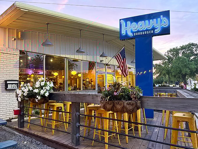 Sunset at Heavy's transforms the patio into a golden-hour haven. Those yellow bar stools aren't just seating—they're front-row tickets to flavor town.
