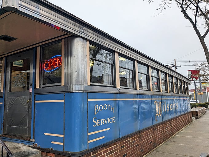 The blue-and-gold façade of Wilson's Diner stands like a time capsule on Waltham's Main Street, promising comfort food salvation to hungry Massachusetts souls.