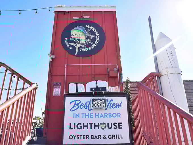 The crimson exterior of Lighthouse Oyster Bar & Grill stands like a culinary lighthouse, promising the "Best View in the Harbor" and delivering on that bold claim.
