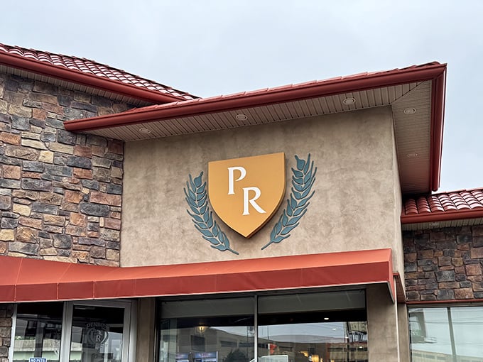 The stone fortress of flavor! Penrose Diner's distinctive exterior with its red roof and chef logo promises comfort food royalty in South Philly.