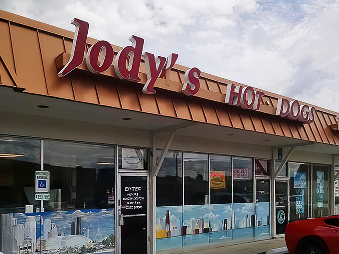 The unassuming storefront of Jody's Hot Dogs in Joliet—where culinary magic happens behind that Chicago skyline window decal.