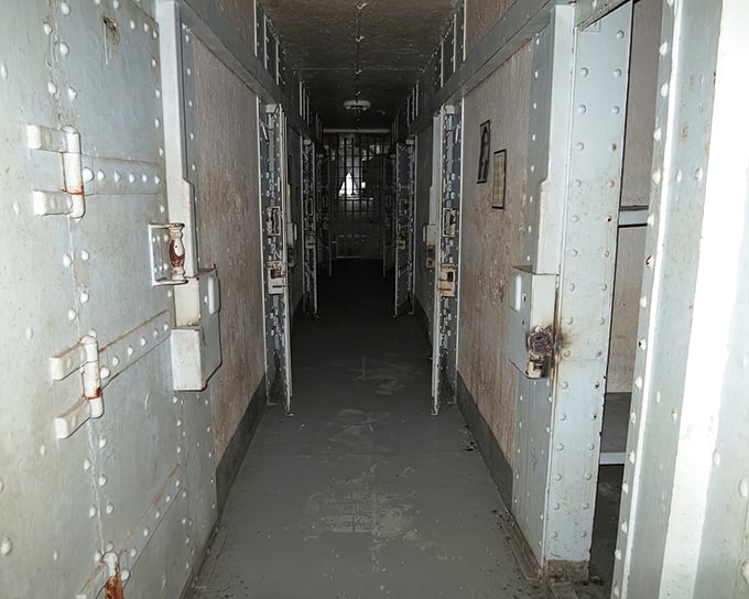The long corridor of steel and silence – where every footstep echoes with stories of those who walked this path before you.