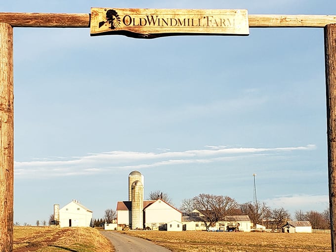 The iconic wooden entrance sign frames a postcard-perfect view of silos and farmhouses against Pennsylvania's endless sky.