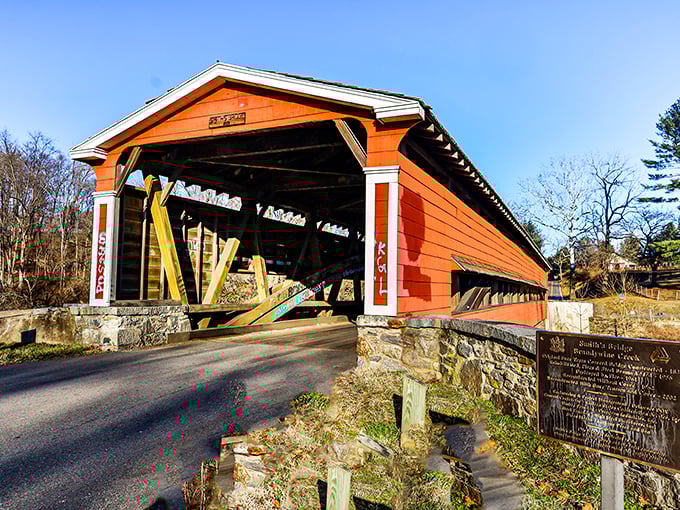 The vibrant red-orange exterior of Smith's Bridge stands like a portal to the past, inviting travelers to slow down and experience a slice of Americana.