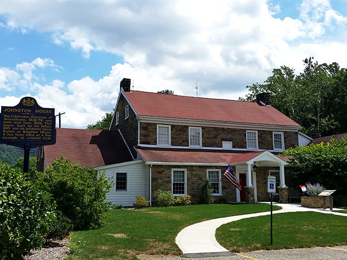 The historic Johnston House stands proudly along the Lincoln Highway, its sturdy stone walls and red roof welcoming travelers just as it did a century ago.