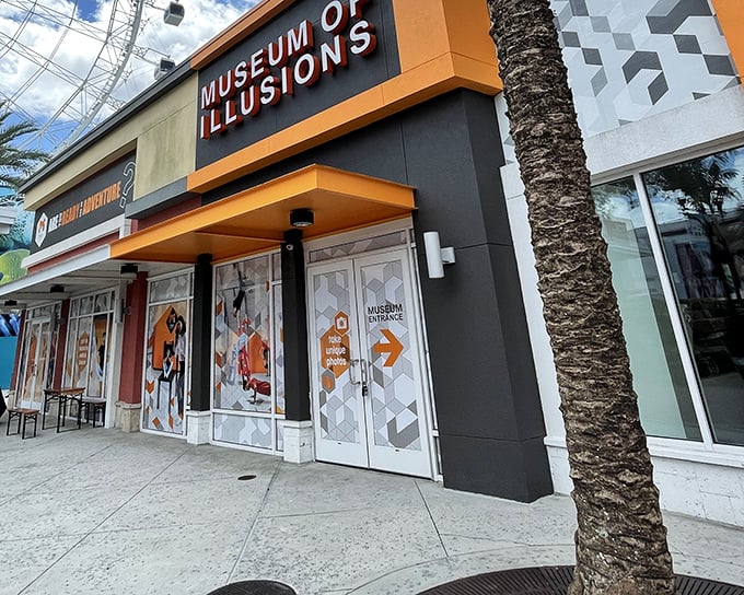 The vibrant orange and black façade of Museum of Illusions Orlando stands out at ICON Park like a magic trick waiting to happen.