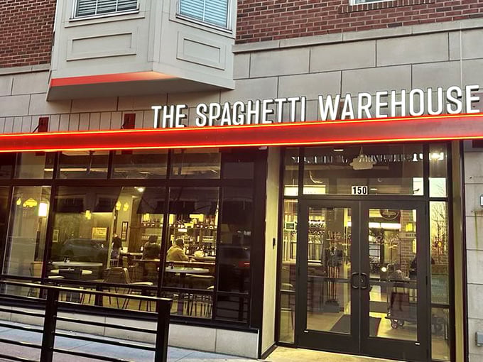 This isn't just any brick building—it's a pasta palace disguised as industrial architecture. Those black awnings hint at the culinary treasures hiding behind that unassuming facade.