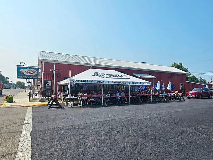 The red barn exterior of Whistle Stop isn't just charming—it's a beacon for hungry travelers. That outdoor seating area practically whispers "stay awhile."