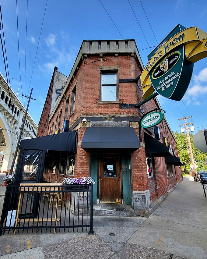 The triangular brick building housing Flat Iron Cafe stands proudly in Cleveland's Flats district, its heraldic shields announcing its Irish heritage like medieval banners.