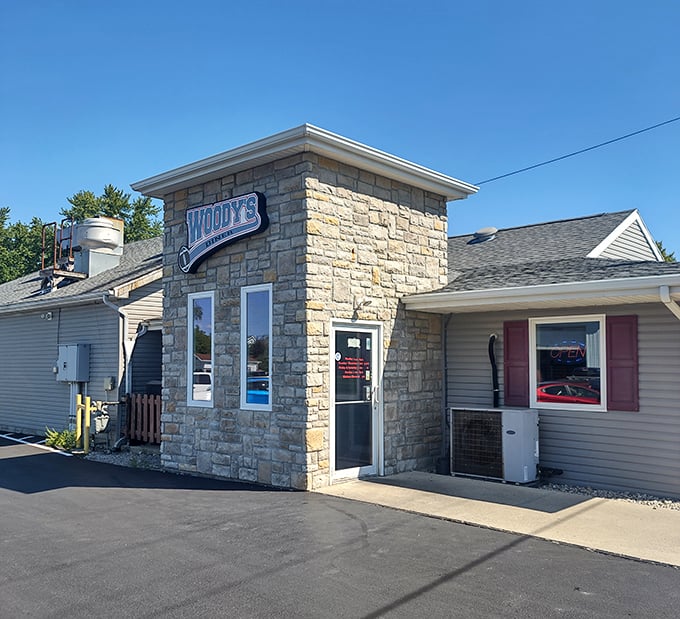 The stone-front entrance of Woody’s welcomes diners with a sturdy charm, inviting all to discover hearty comfort food inside.