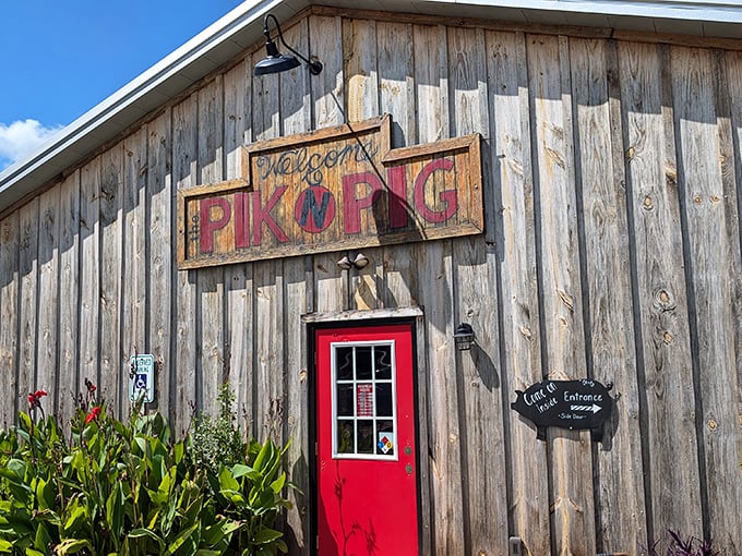That hand-painted sign says it all—welcome to barbecue paradise. The red door practically winks at you, promising smoky treasures within.