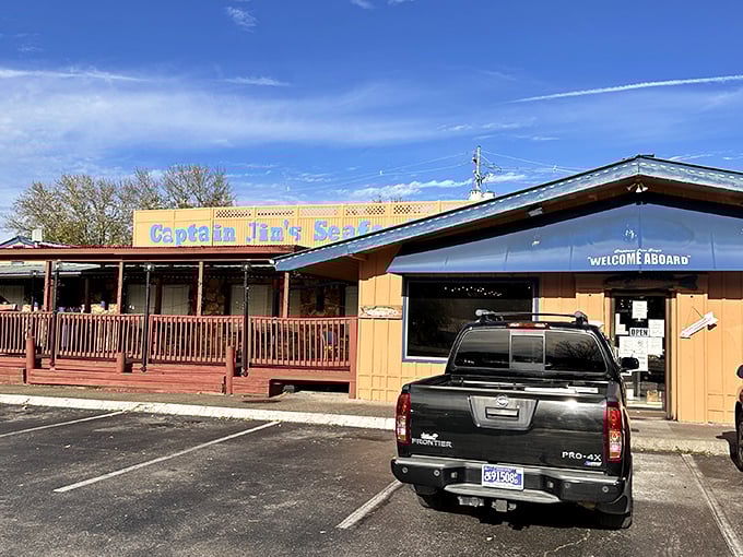 The unassuming exterior of Captain Jim's Seafood Buffet beckons seafood lovers with its blue sign and welcoming wooden deck—proof that culinary treasures often hide in plain sight.