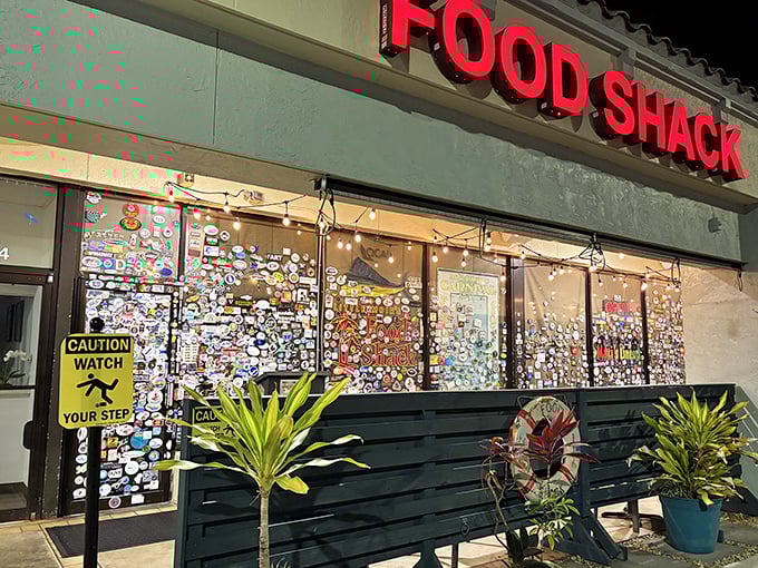 The sticker-covered windows of Food Shack tell a story before you even walk in—each one a testament to a happy diner's journey.