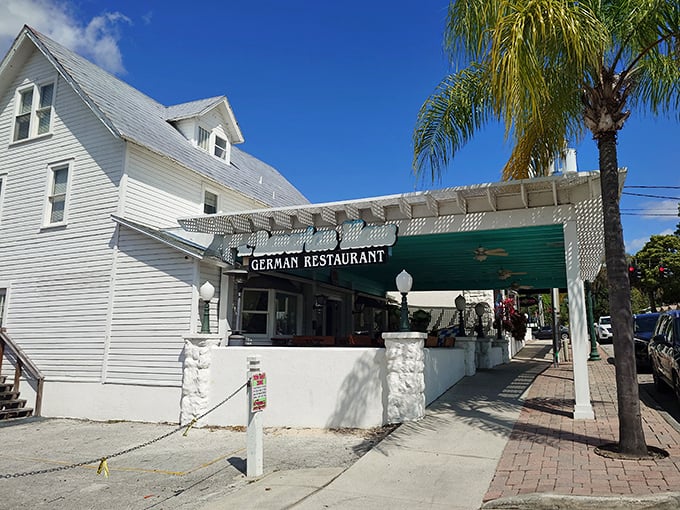 The welcoming facade of The Bavarian Haus in Mount Dora beckons like an old friend, promising authentic German comfort under that distinctive turquoise awning. 