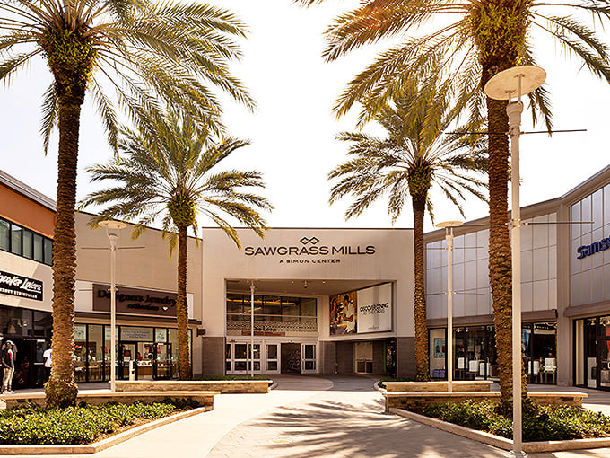 Palm trees standing like elegant sentinels at the entrance – Florida's way of saying "prepare your credit cards for what lies beyond."