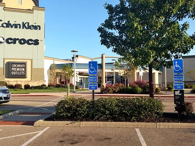 The retail promised land beckons at dusk, where Cincinnati Premium Outlets transforms shopping from chore to adventure. Those glowing storefronts practically whisper "bargains inside!"