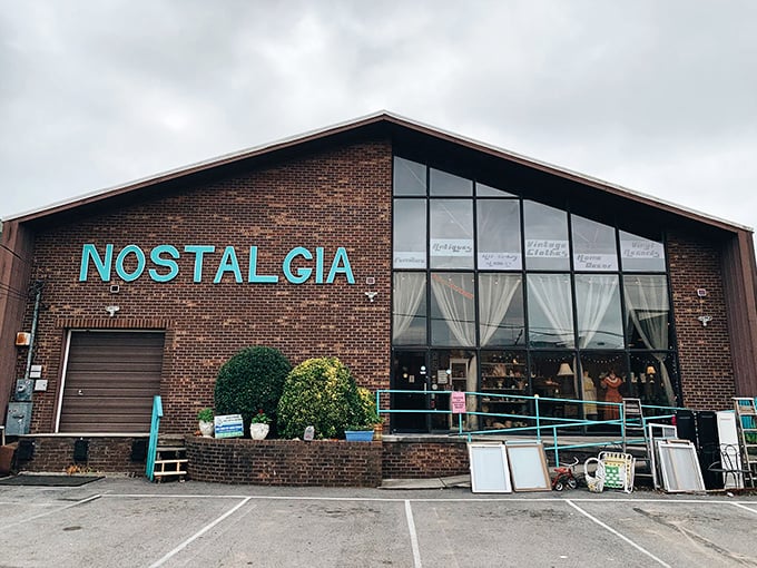 The turquoise sign against brick is like a beacon for treasure hunters—Nostalgia's exterior promises adventures in time travel disguised as shopping.