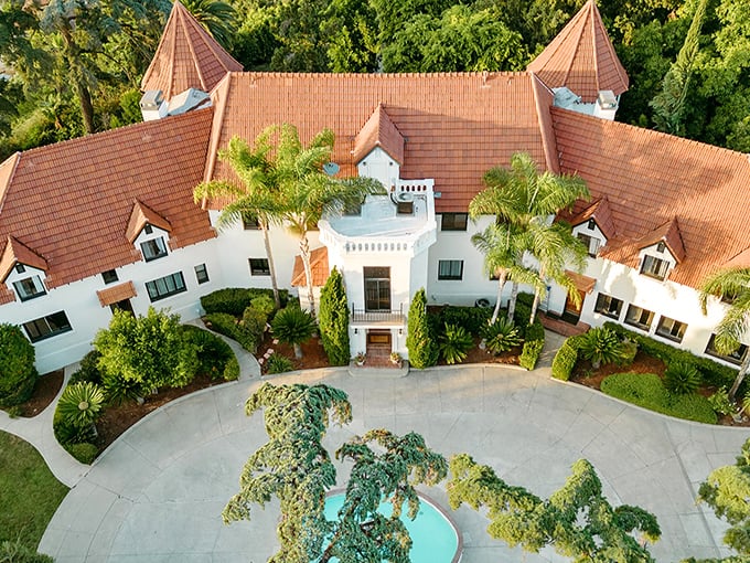 A bird's-eye view of Wrensmoor Castle reveals its fairy tale charm—twin turrets standing like sentinels while palm trees remind you this European fantasy exists in sunny California.
