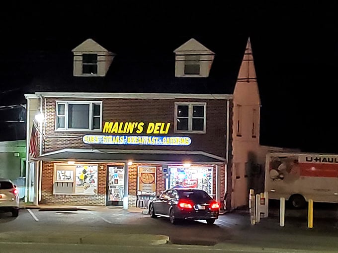 The yellow sign glows like a beacon of hope for the hungry traveler. Malin's Deli stands proudly against the night sky, promising delicious salvation inside.