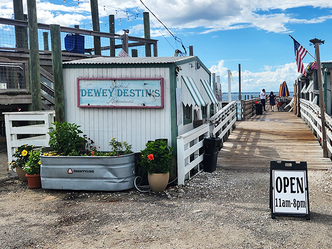 The entrance to paradise isn't pearly gates, but a weathered wooden boardwalk leading to Dewey Destin's—where seafood dreams come true and calories don't count.