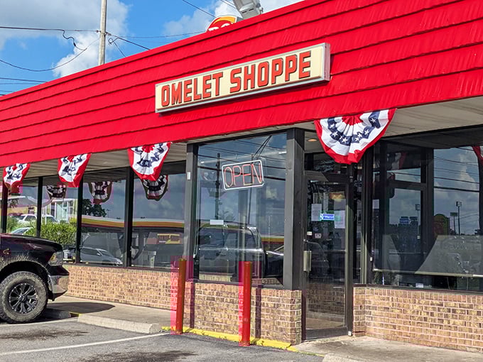 The bright red exterior of Omelet Shoppe stands out like a beacon for hungry travelers. Those patriotic bunting flags practically scream "American comfort food inside!"