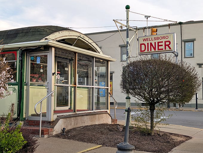 The classic stainless steel exterior of Wellsboro Diner stands like a time capsule on Main Street, complete with that iconic red sign that practically screams "comfort food ahead!"