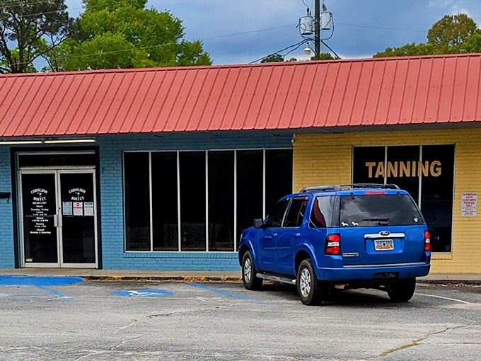 The unassuming blue exterior with its bright orange roof houses culinary treasures that locals drive miles to experience. Southern food paradise hiding in plain sight.