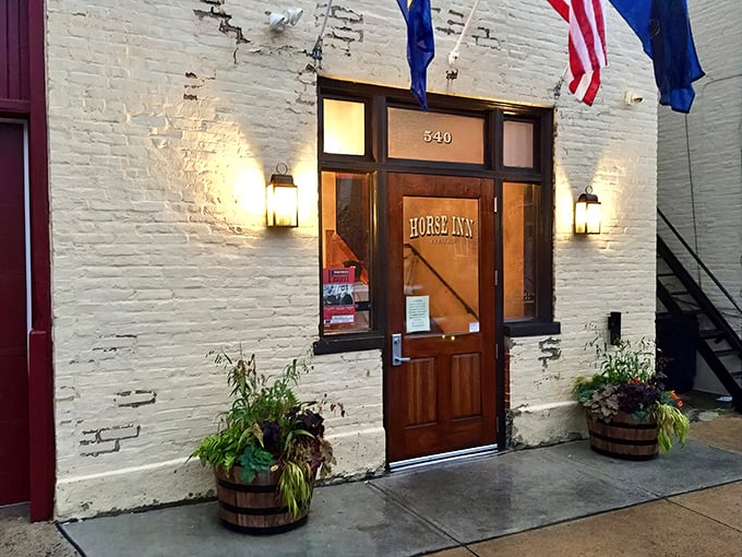 The white brick façade of Horse Inn glows with welcome, flags fluttering above like a beacon to hungry travelers seeking culinary adventure in Lancaster.