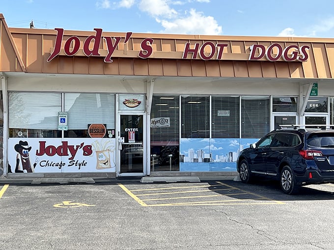 The unassuming storefront of Jody's Hot Dogs in Joliet—where culinary magic happens behind that Chicago skyline window decal.